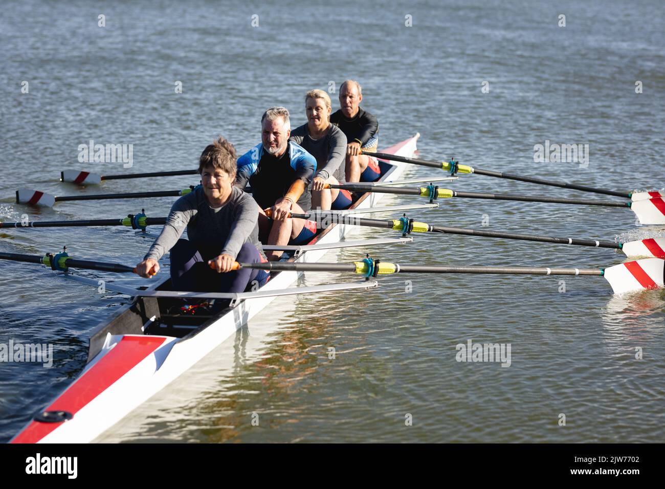 Senior caucasian rowing team rowing the boat on the lake Stock Photo ...