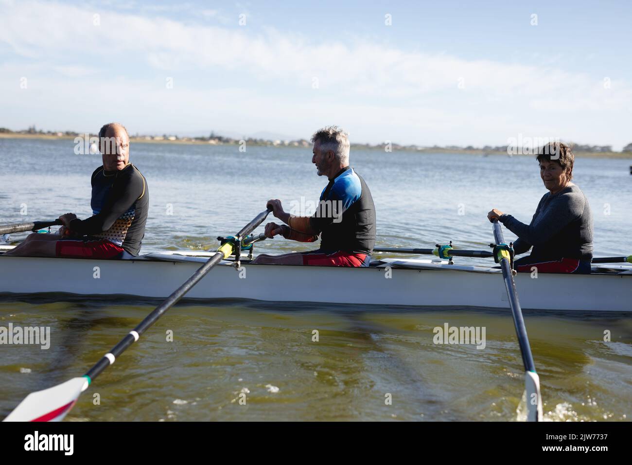 Senior caucasian rowing team rowing the boat on the lake Stock Photo ...