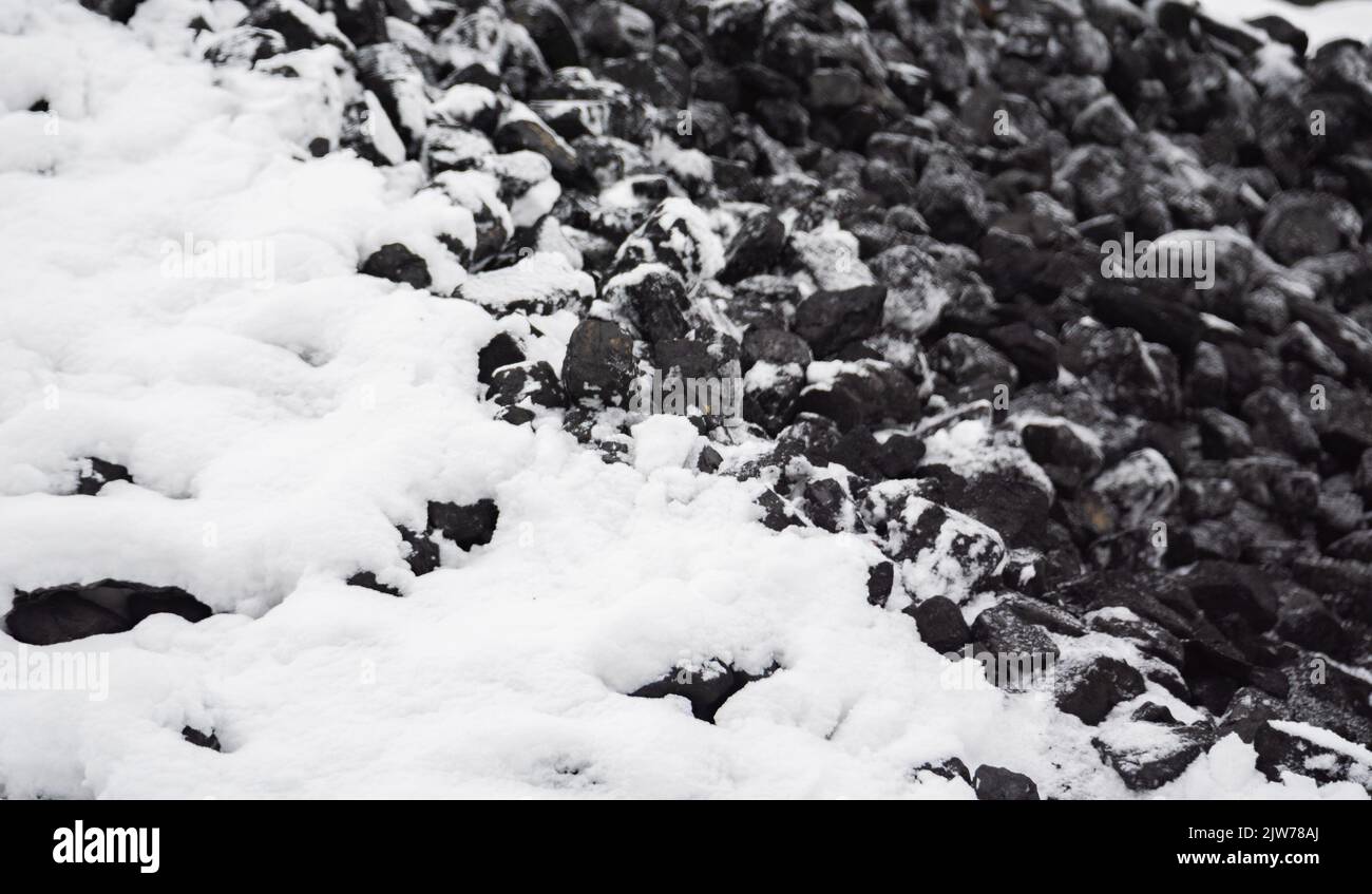 Coal covered with snow in the fuel store. Sale of coal in winter. Coal ...