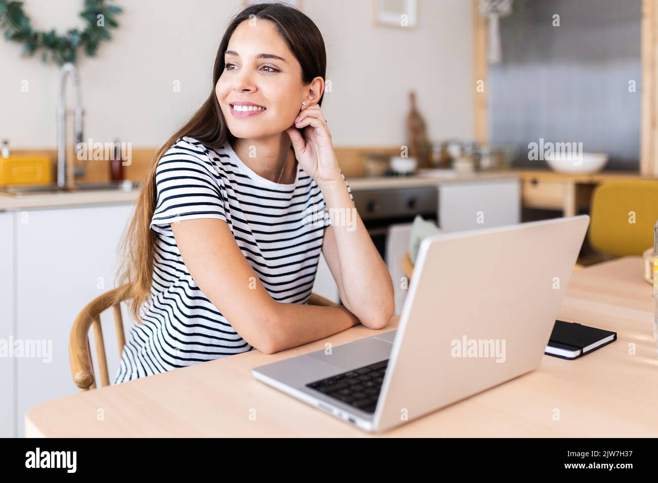 Serene young woman having a break from working on laptop computer at ...