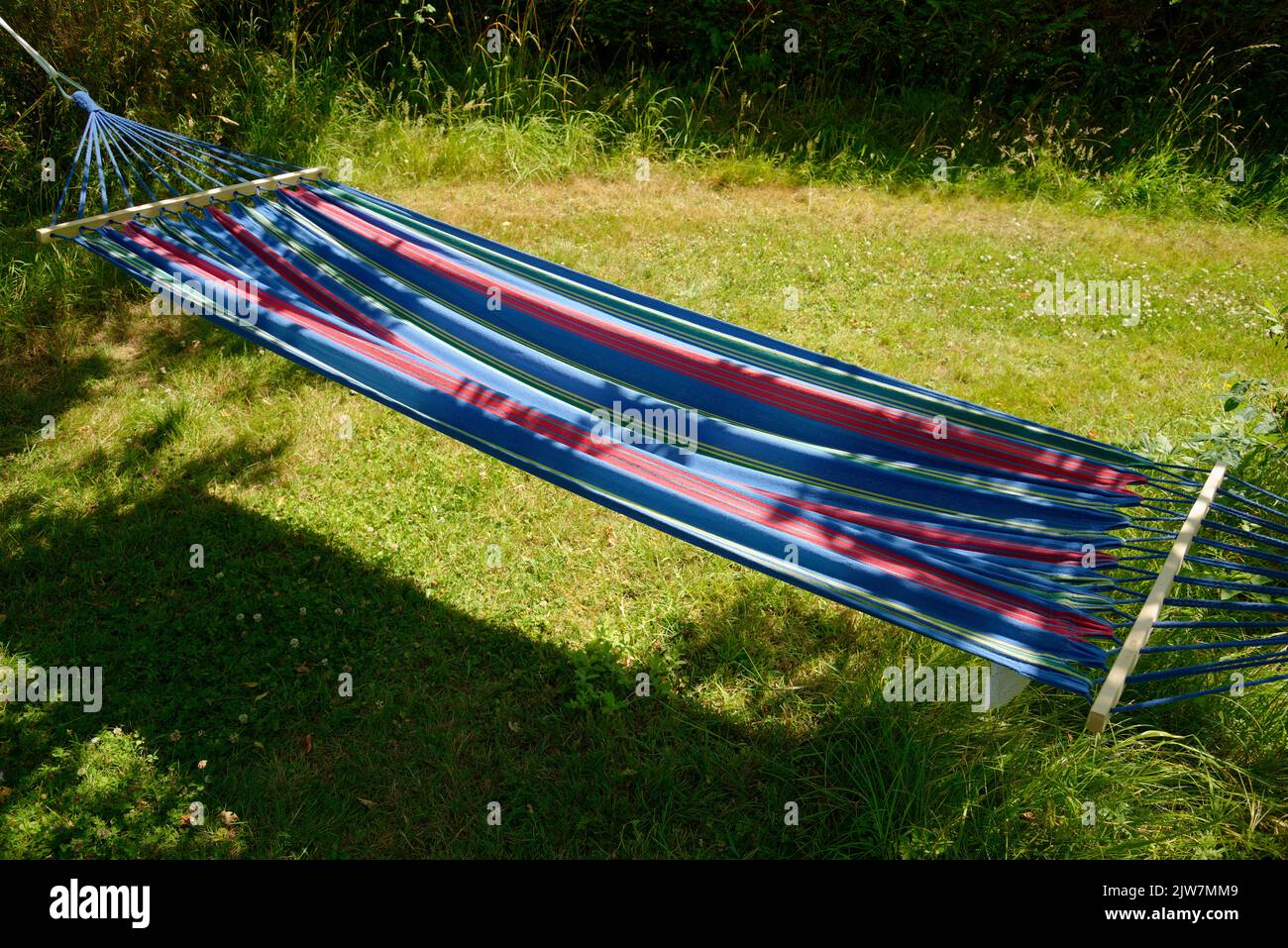 A garden hammock in summer. Relax in suspended comfort in a soft fabric ...