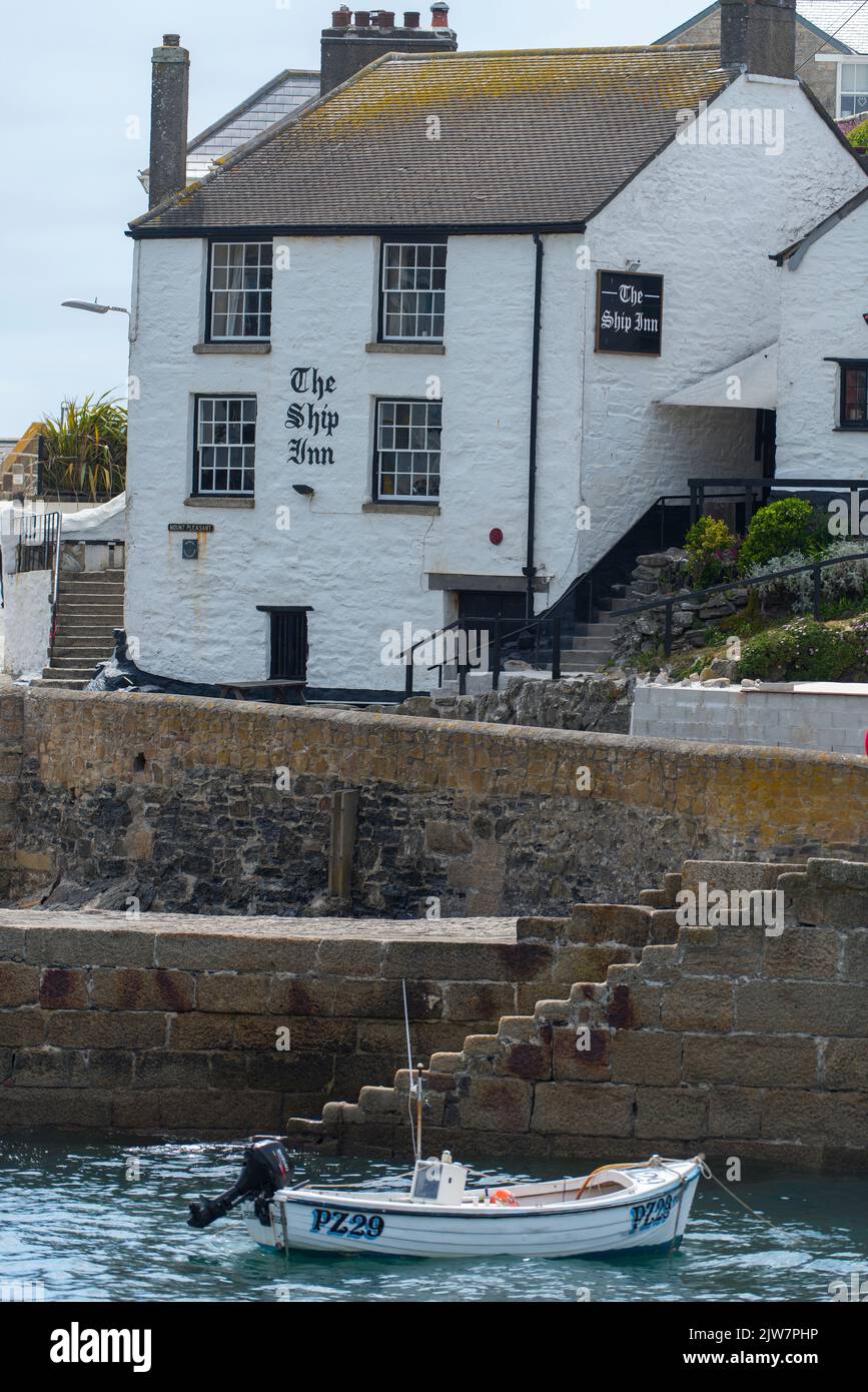 The Ship Inn Pub Porthleven, with a small fishing boat moored up ...