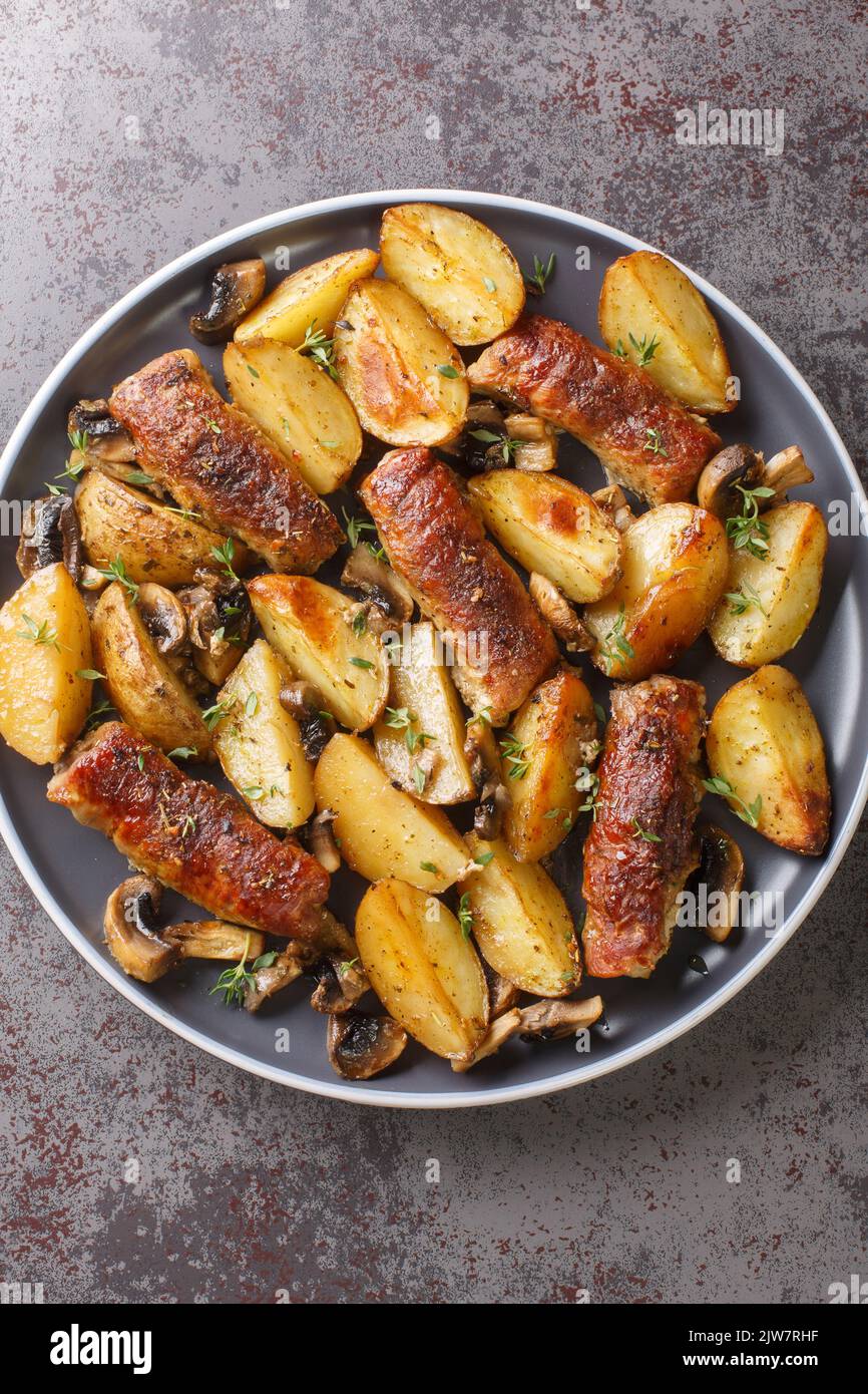 Baked pork rolls with mushrooms and potatoes close-up in a plate on the ...