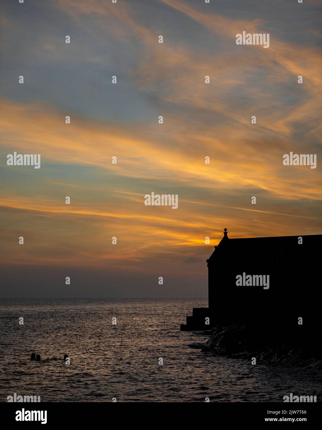 Family's in silhouette enjoying the sun sat at Porthleven Lifeboat ...