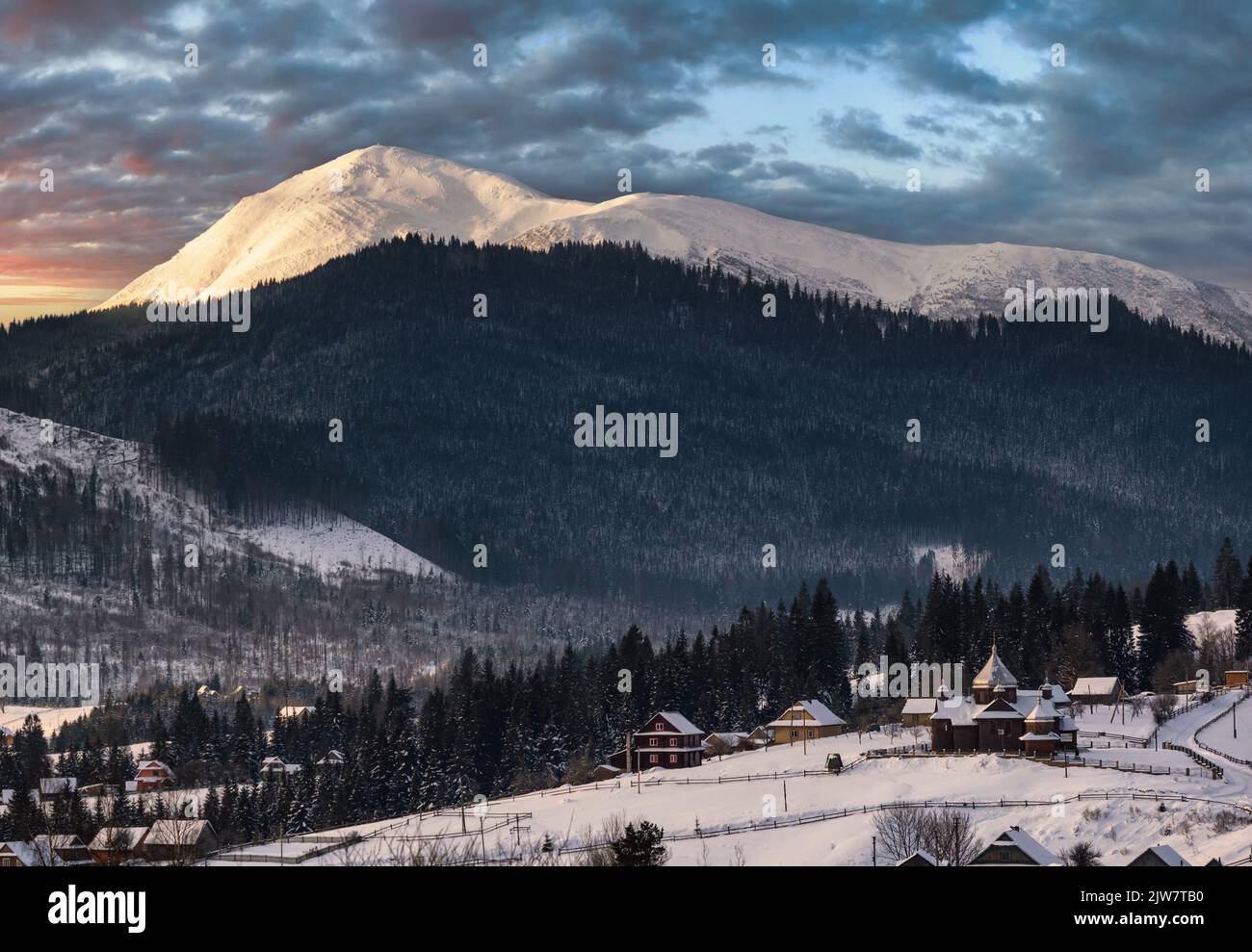 Small alpine village and winter snowy mountains in first sunrise ...