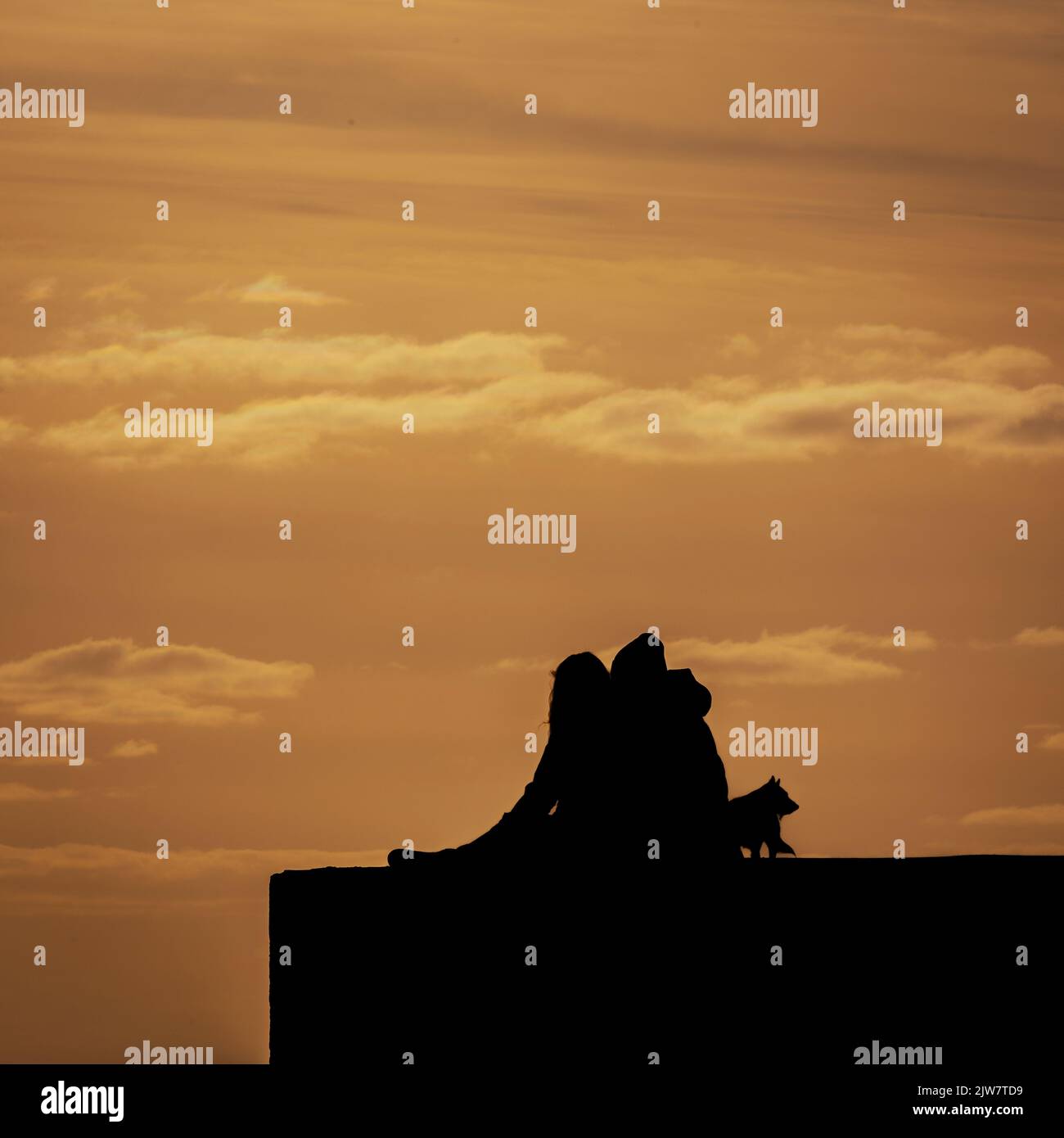 Family's in silhouette enjoying the sun sat at Porthleven Lifeboat ...