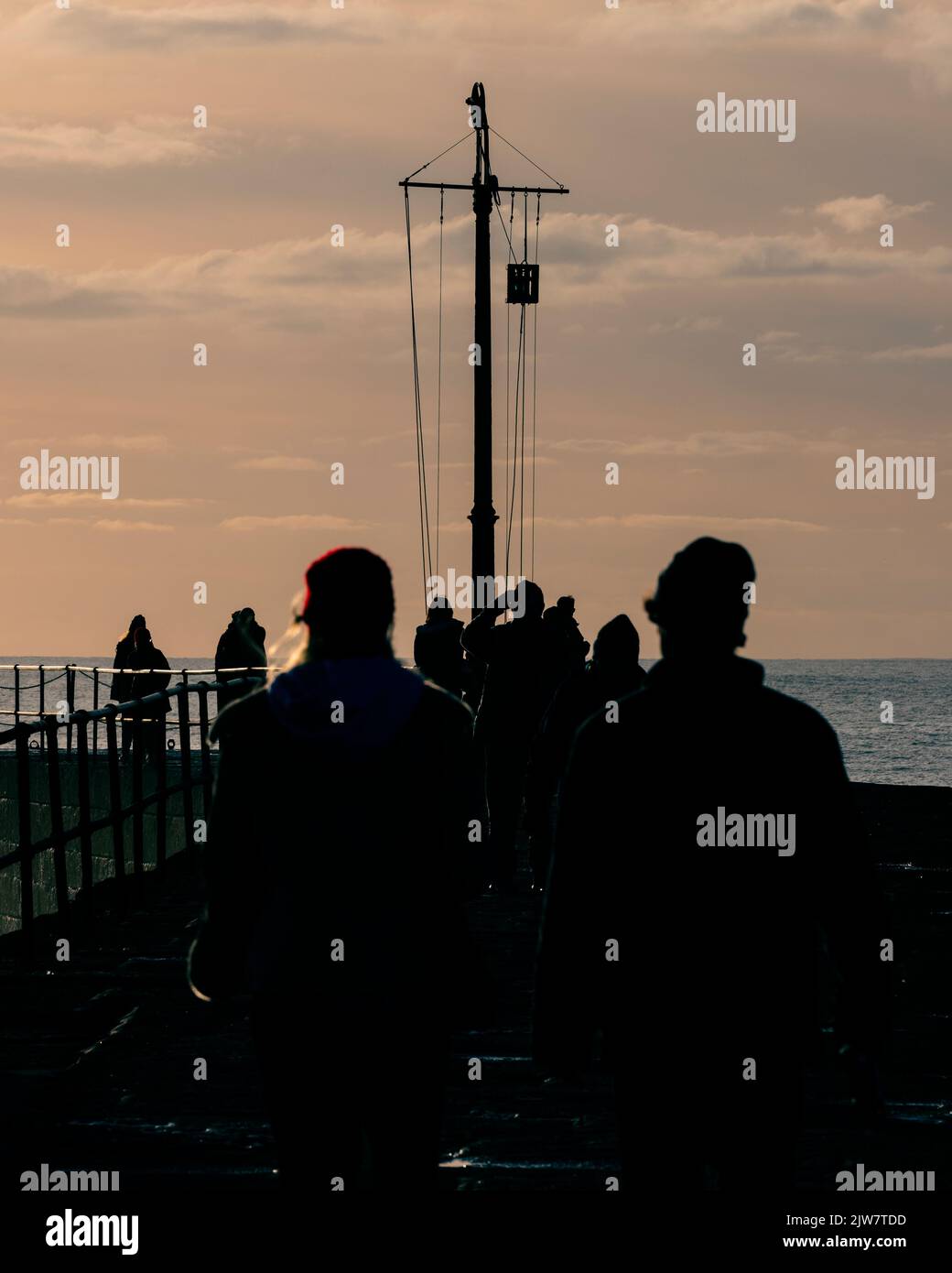 Family's in silhouette enjoying the sun sat at Porthleven Lifeboat ...
