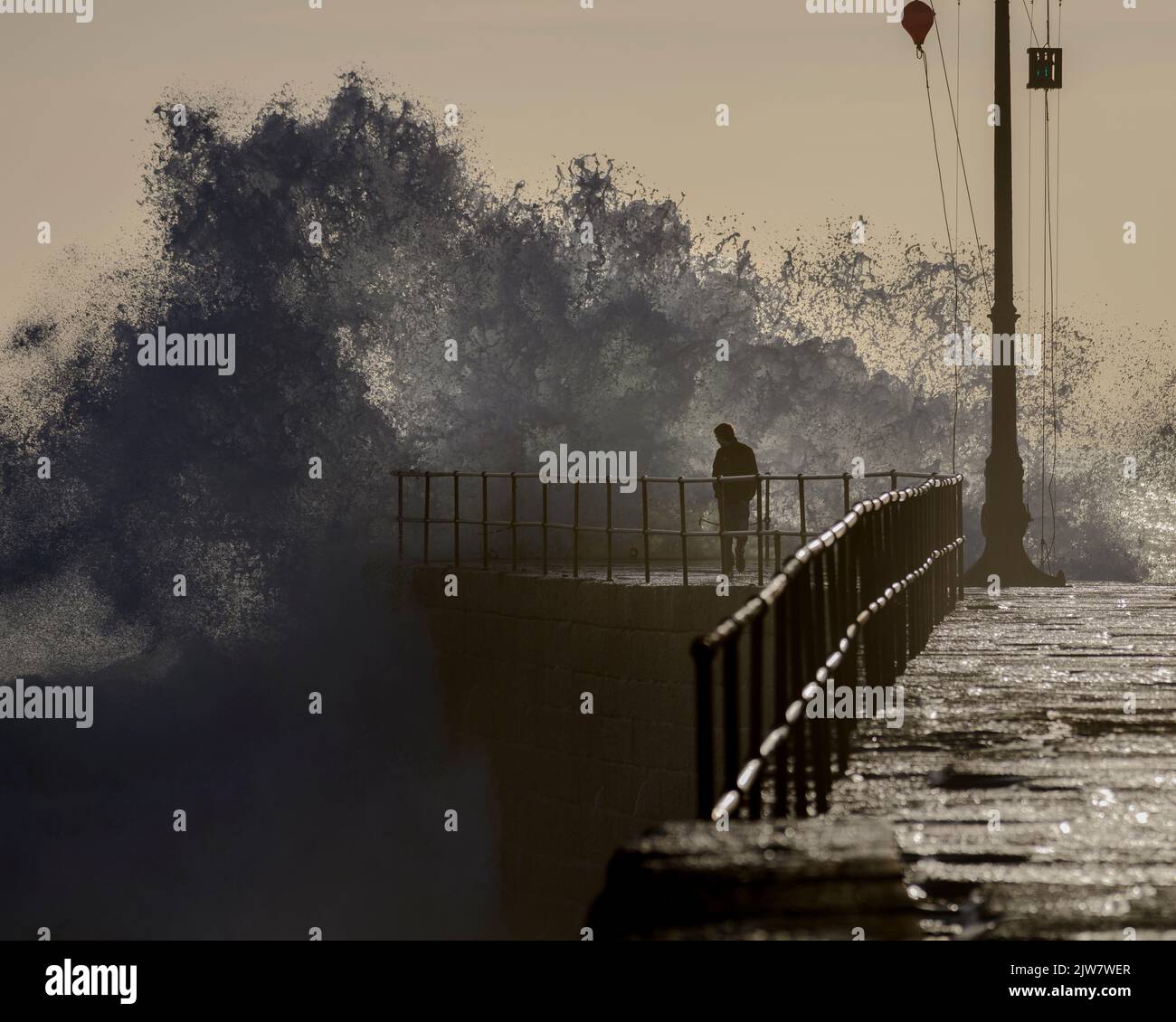 Crazy man taking on a massive wave hitting Porthleven pier Stock Photo ...