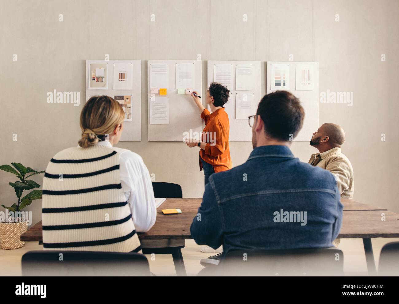 Female manager giving a presentation to her team during a meeting ...