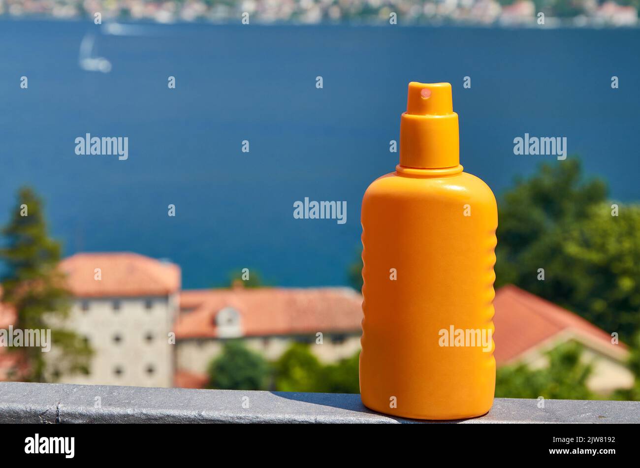 Orange bottle of a sun lotion spray with a sea in a background Stock ...