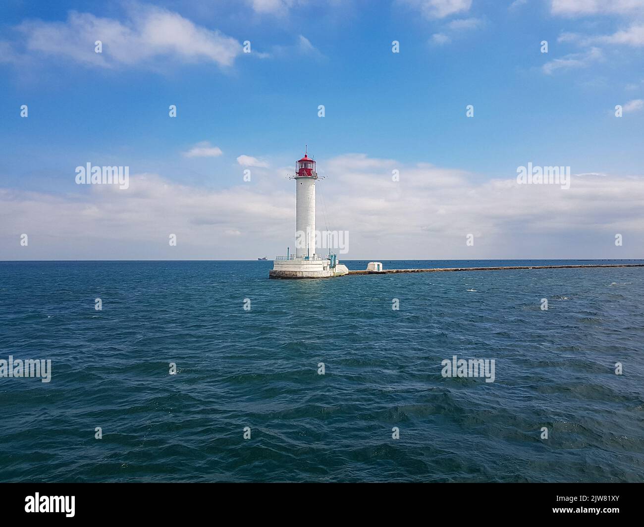 Seascape Sea with lighthouse, calm water and white clouds background ...