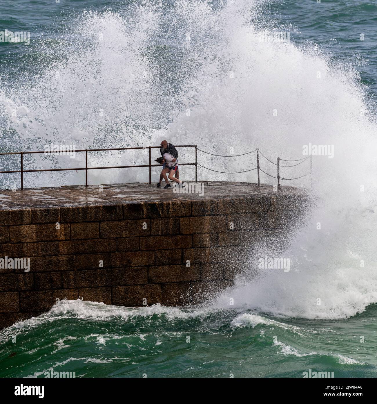 Tourists getting caught out by big waves crashing over Porthleven pier ...