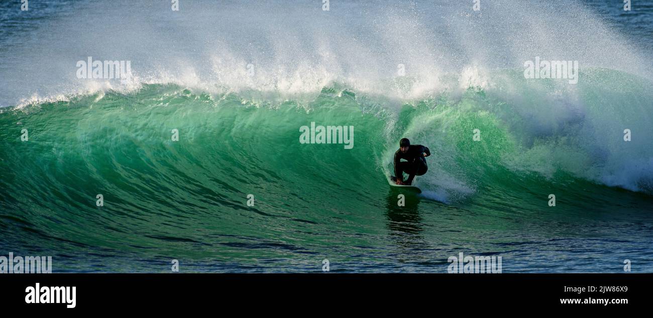 Surfer enjoying the amazing barrelling waves on Porthleven reefs ...