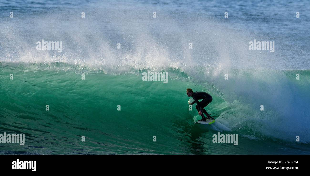 Surfer enjoying the amazing barrelling waves on Porthleven reefs ...