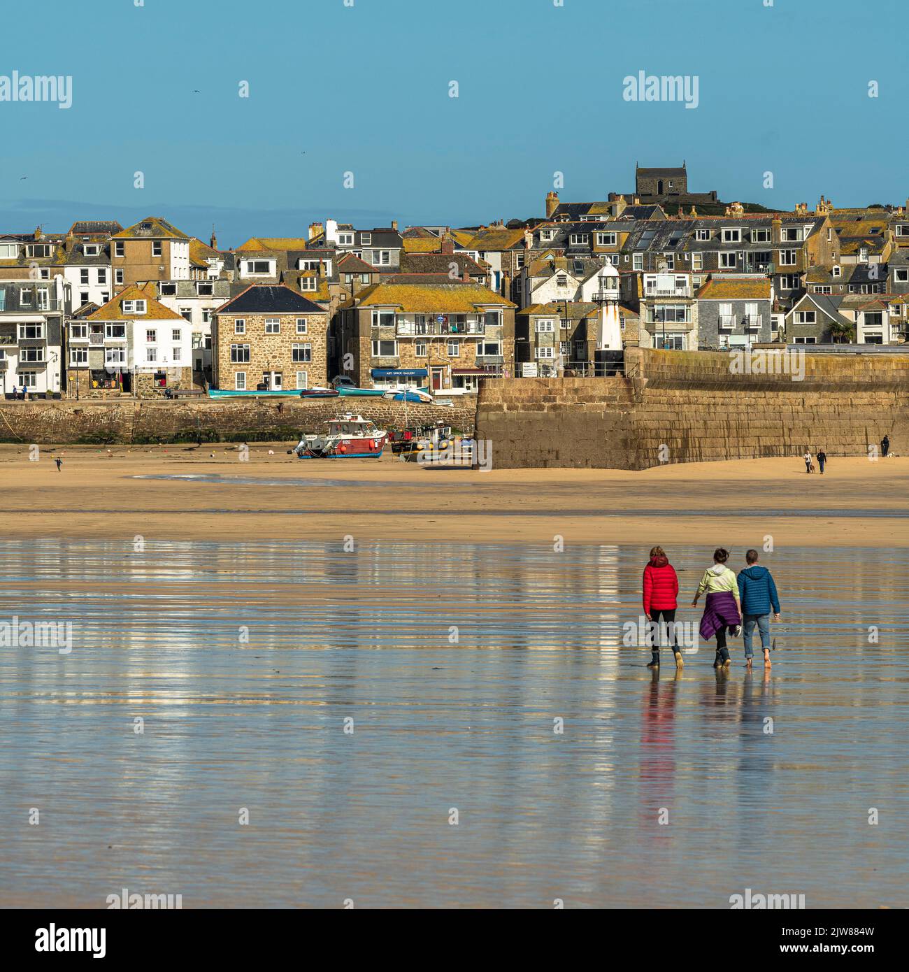 Visitors taking time to walk Porthminster beach to St Ives harbour at ...