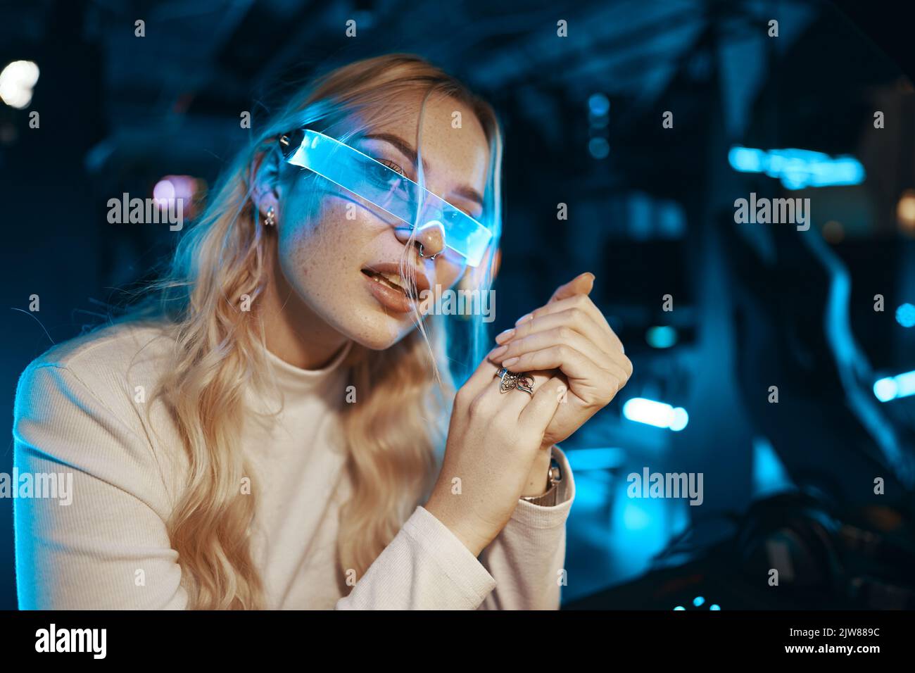 Cute blonde in futuristic fashion style. Neon glasses for a young woman ...