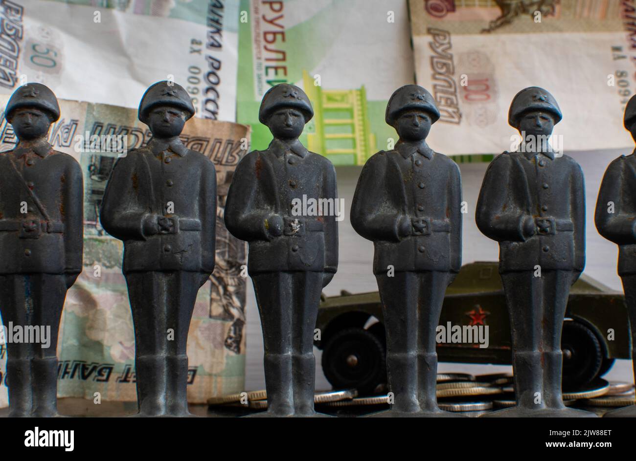 Old tin soldiers close-up on blurred background of paper Russian rubles ...