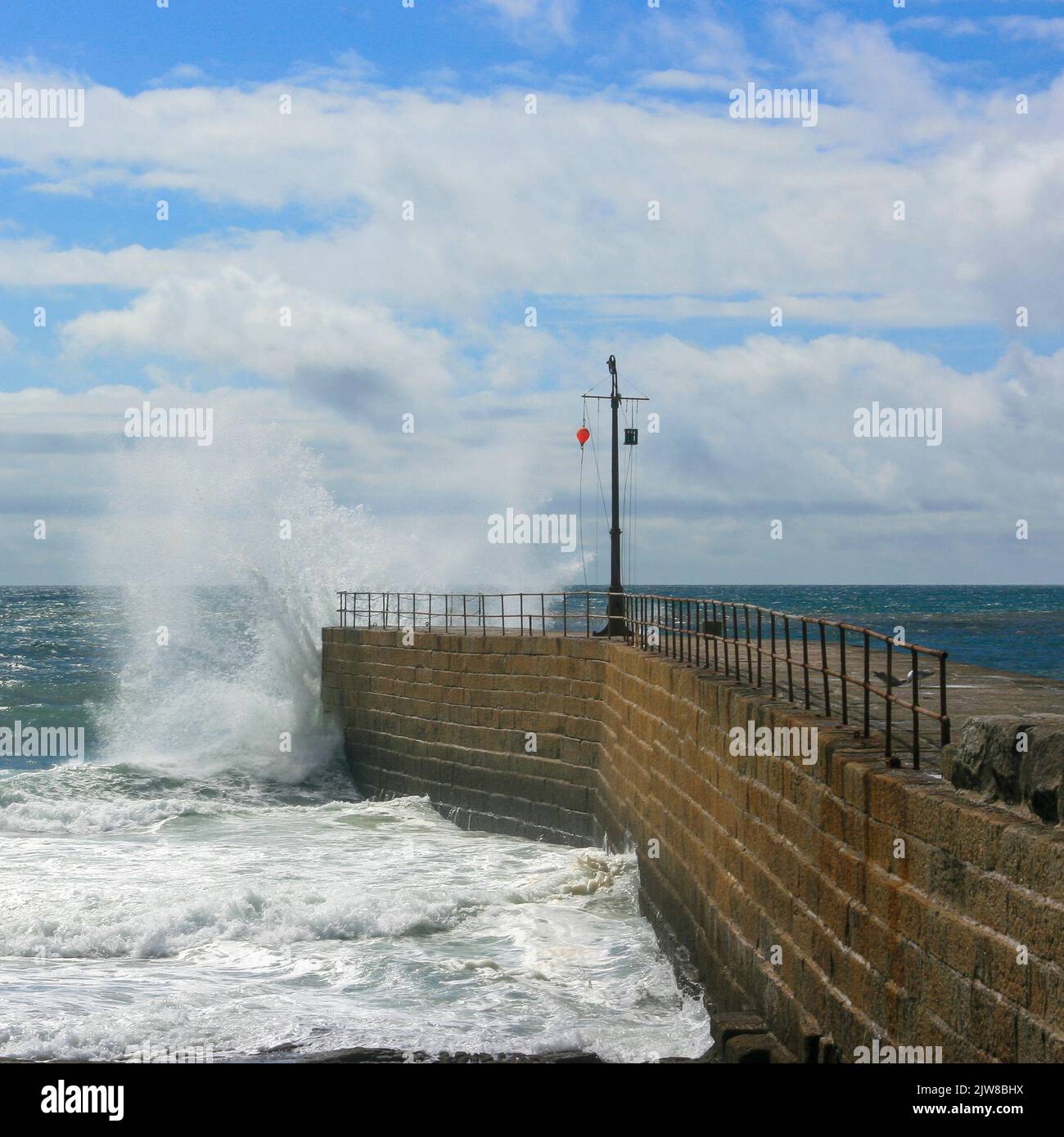 Large wave crashing into the end of Porthleven pier Stock Photo - Alamy