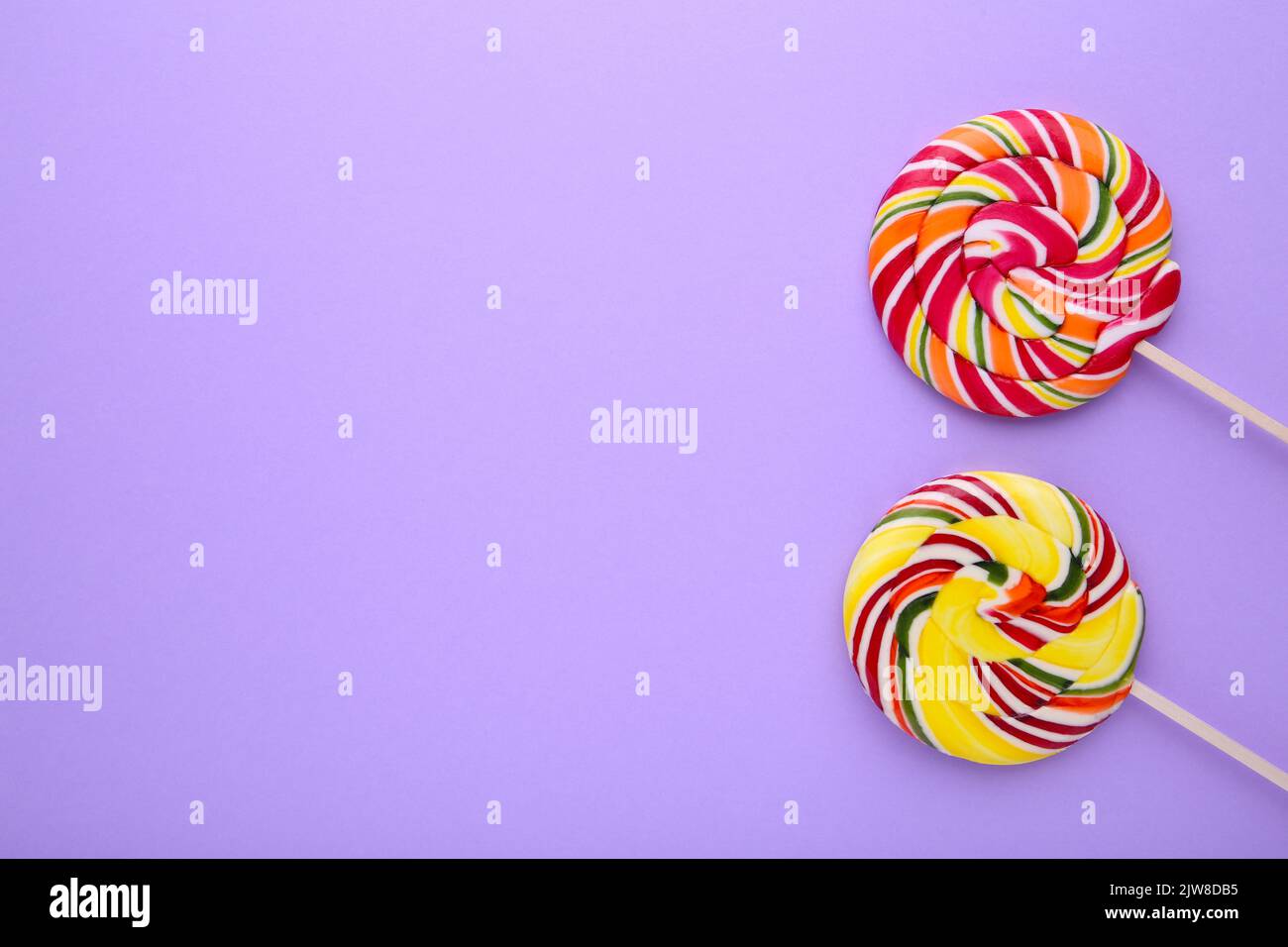 Colorful lollipops on purple background. Studio shot Stock Photo - Alamy