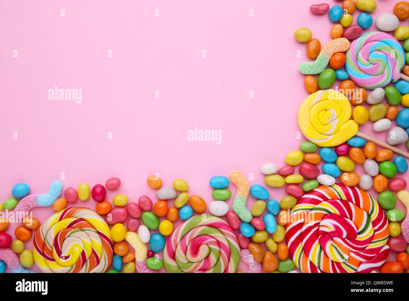 Colorful lollipops and different colored round candy on pink Stock ...
