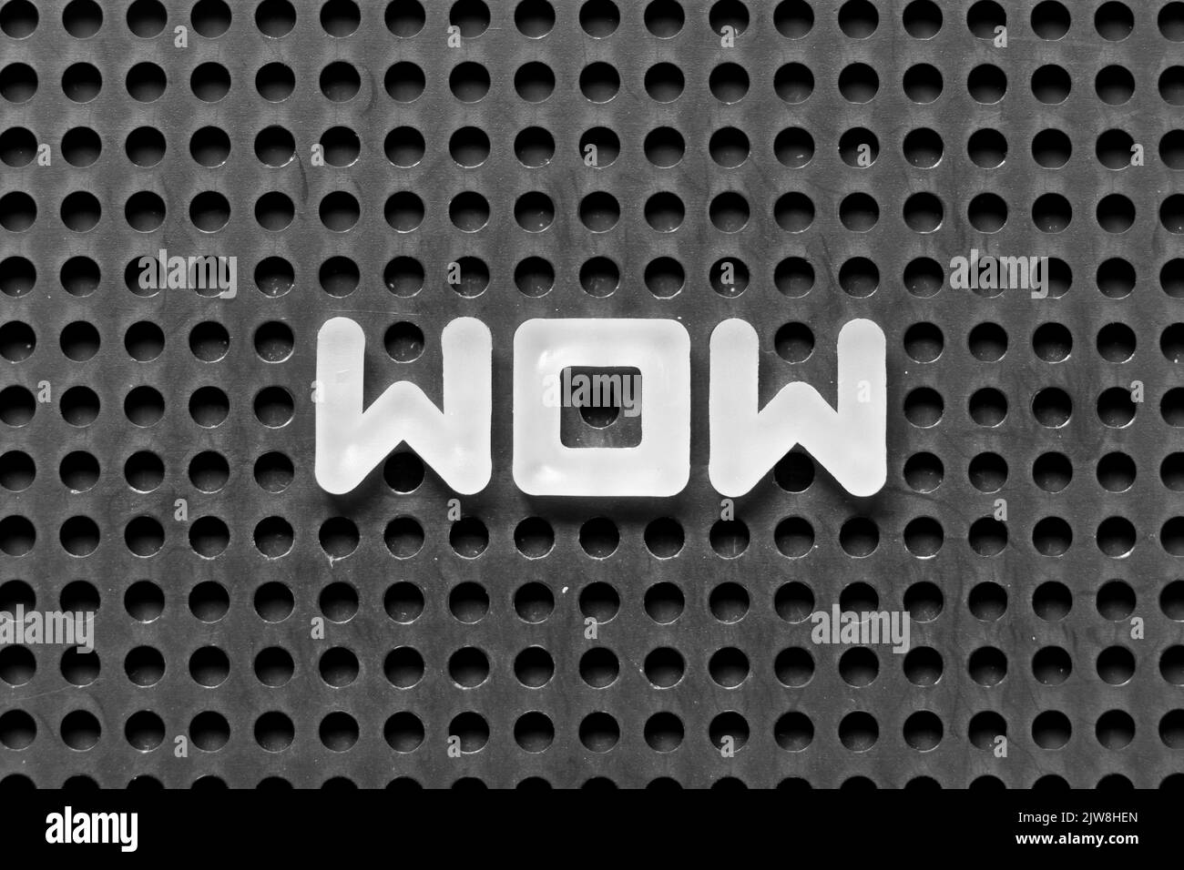 White alphabet letter in word wow on black pegboard background Stock ...