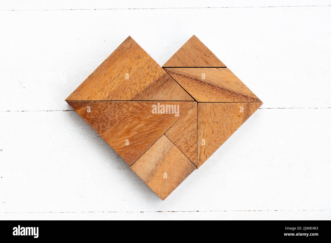 Wood tangram puzzle in heart shape on white wood background Stock Photo ...