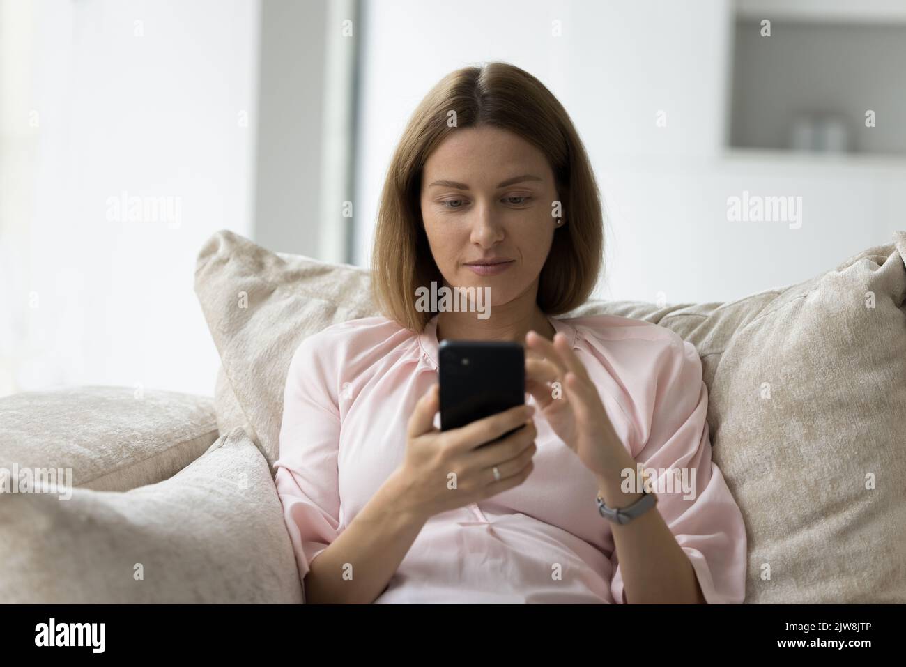 Focused pensive 30s smartphone user woman chatting, typing message ...