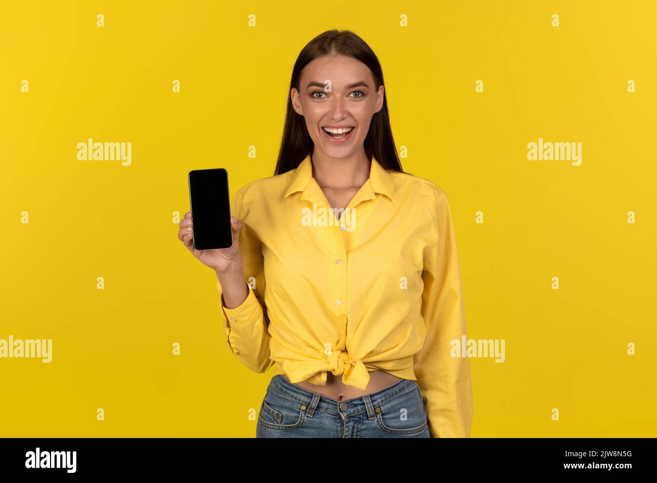 Happy Lady Holding Phone Showing Blank Screen Over Yellow Background ...