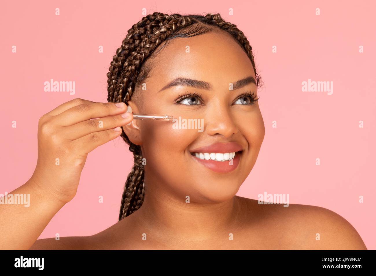 African American Lady Applying Facial Serum Moisturizing Skin, Pink ...