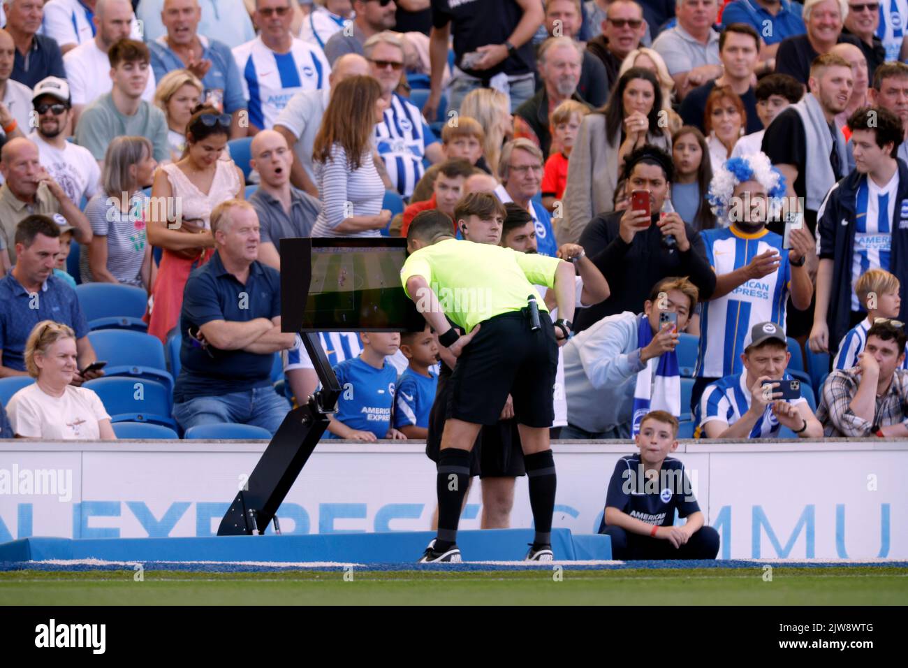 Referee Tony Harrington checks the pitch side monitor for a VAR ...