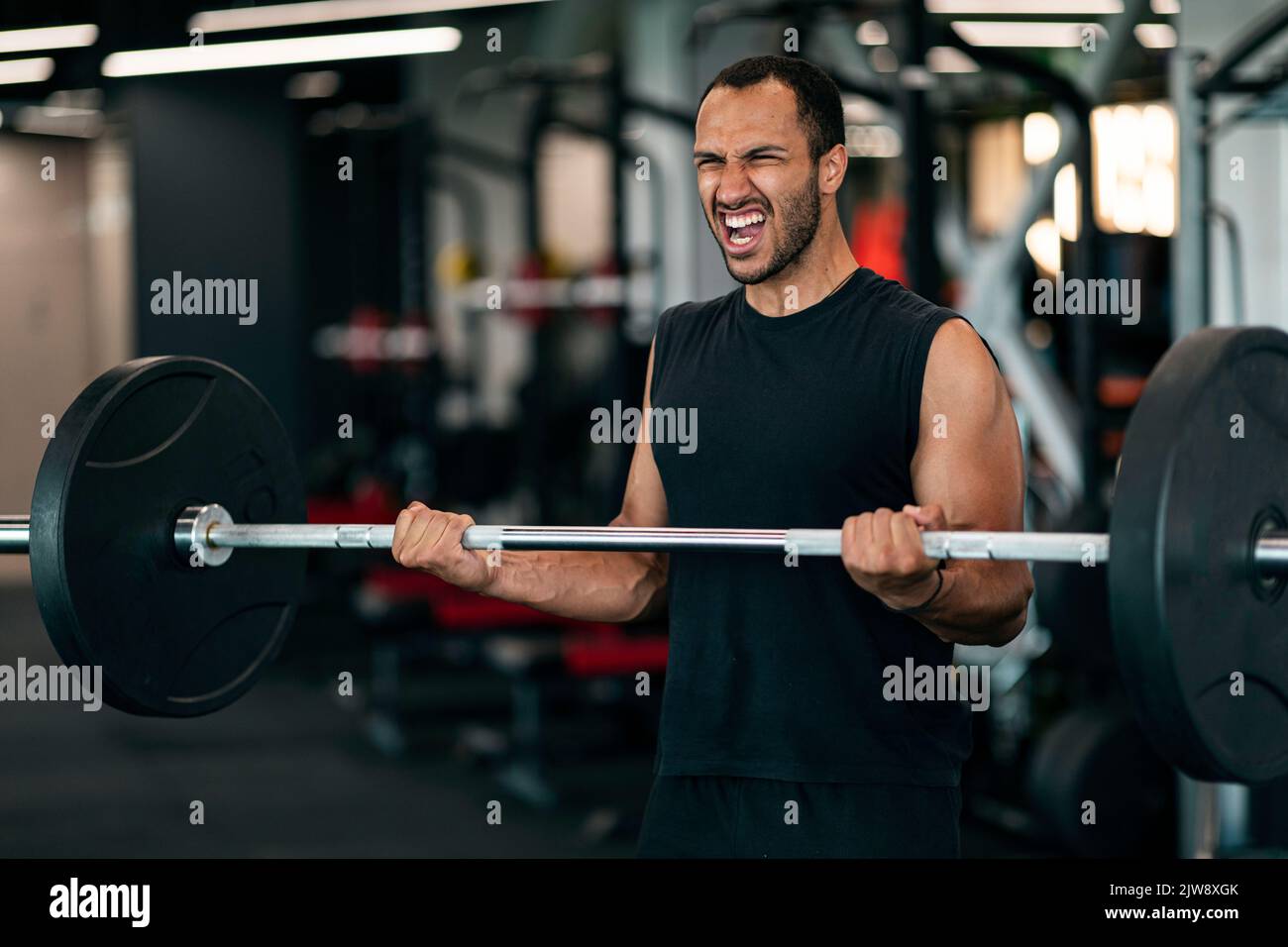 Black Athletic Man Screaming While Making Effort To Lift Barbell At Gym ...