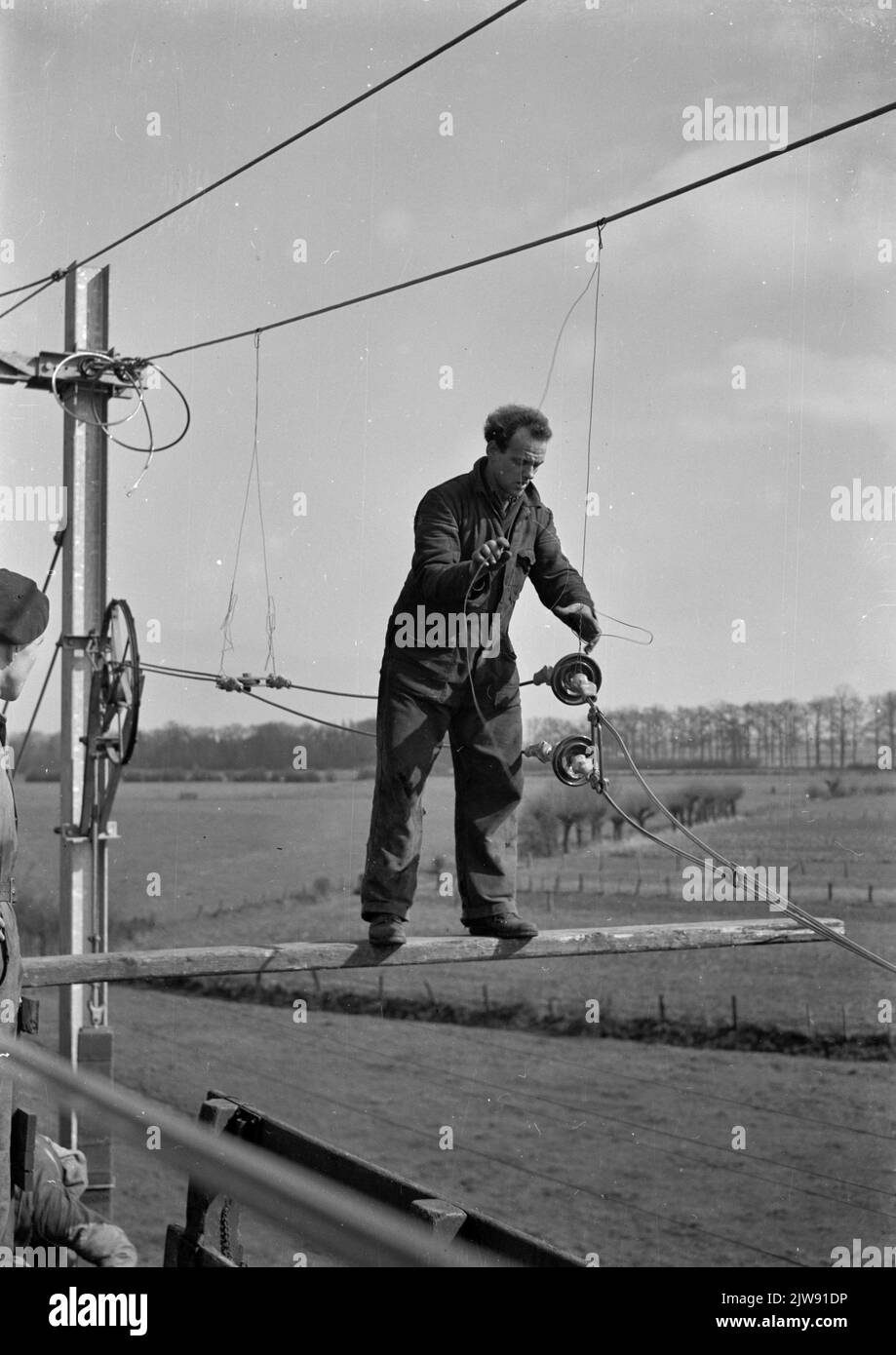 Image of an electrician during the mounting of the overhead line of the ...