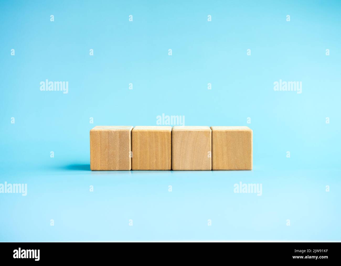 4 wood blocks isolated on blue background with copy space. Empty blank ...