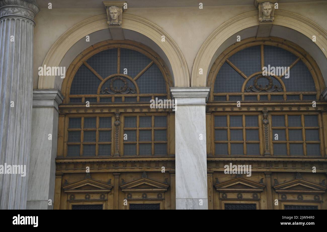 Old Neoclassical building facade with arched wooden doors and Ionic ...