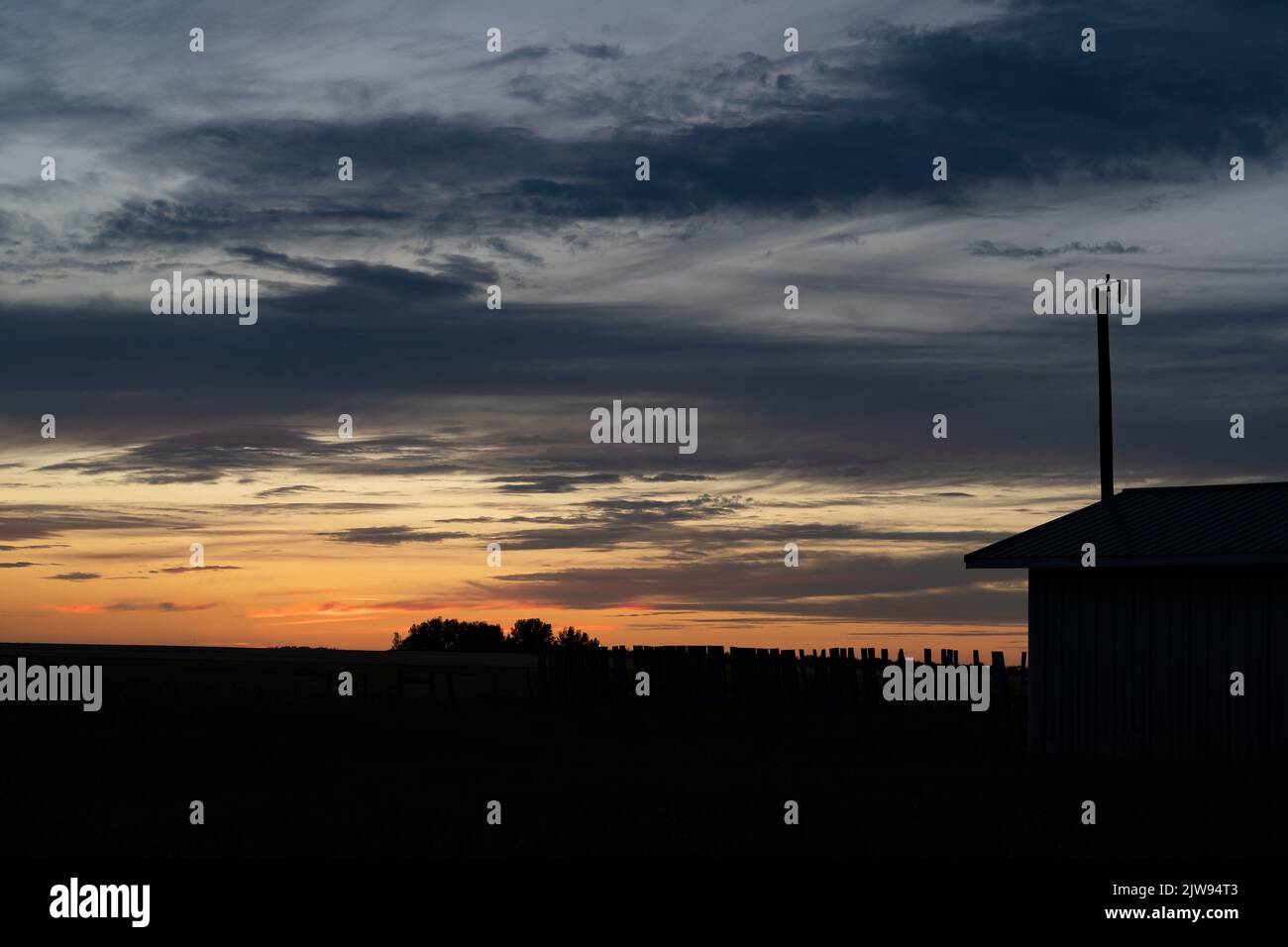 Country home sunset silhouette scene on the Alberta prairies in Rocky ...