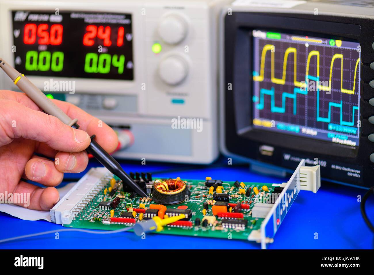 A closeup of technician hands testing an electronic circuit board Stock ...