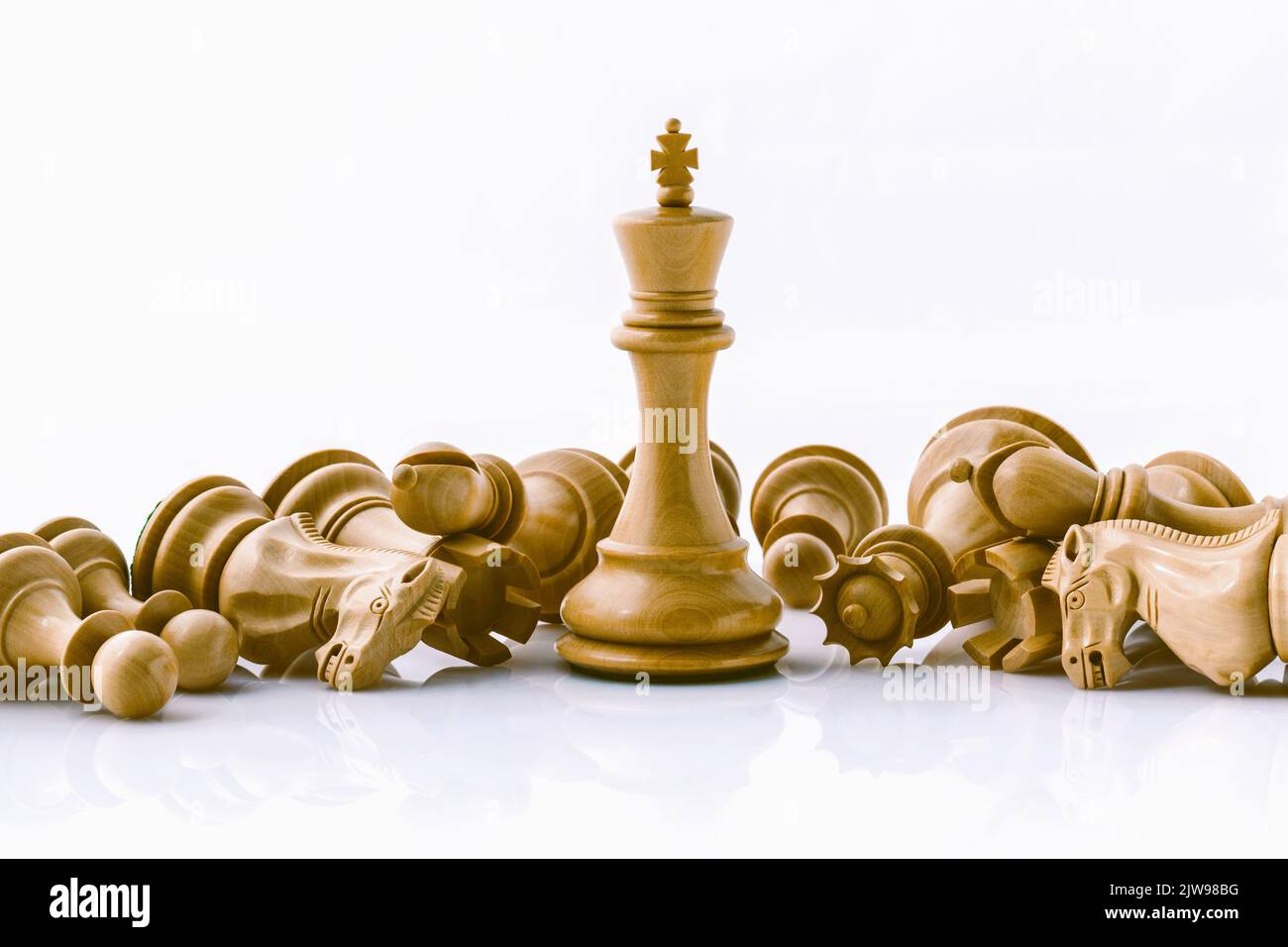 Wooden fallen white chess pieces with a king in the center isolated on ...