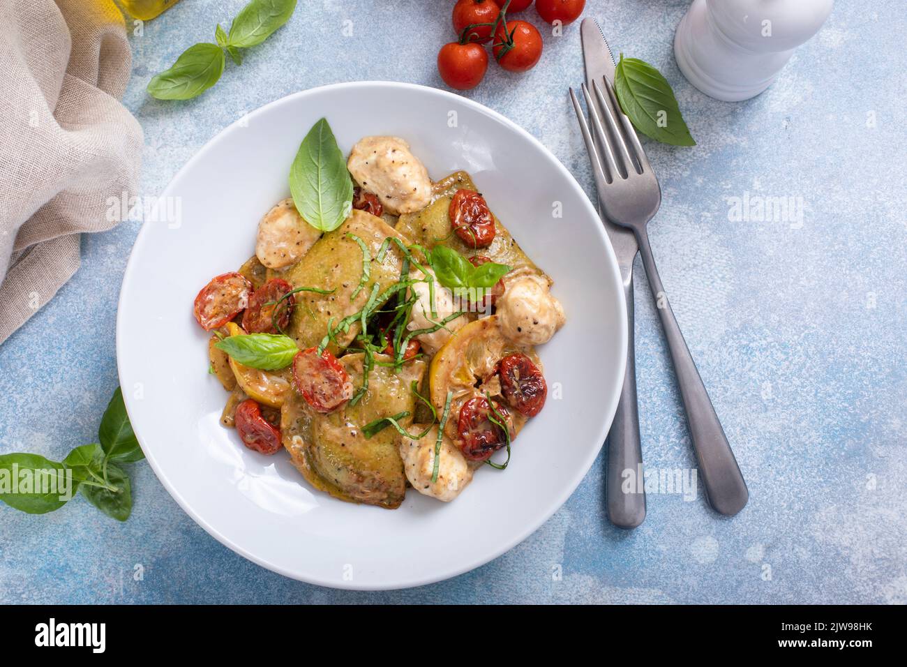 Ravioli with basil, tomatoes and mozzarella in tomato sauce Stock Photo ...