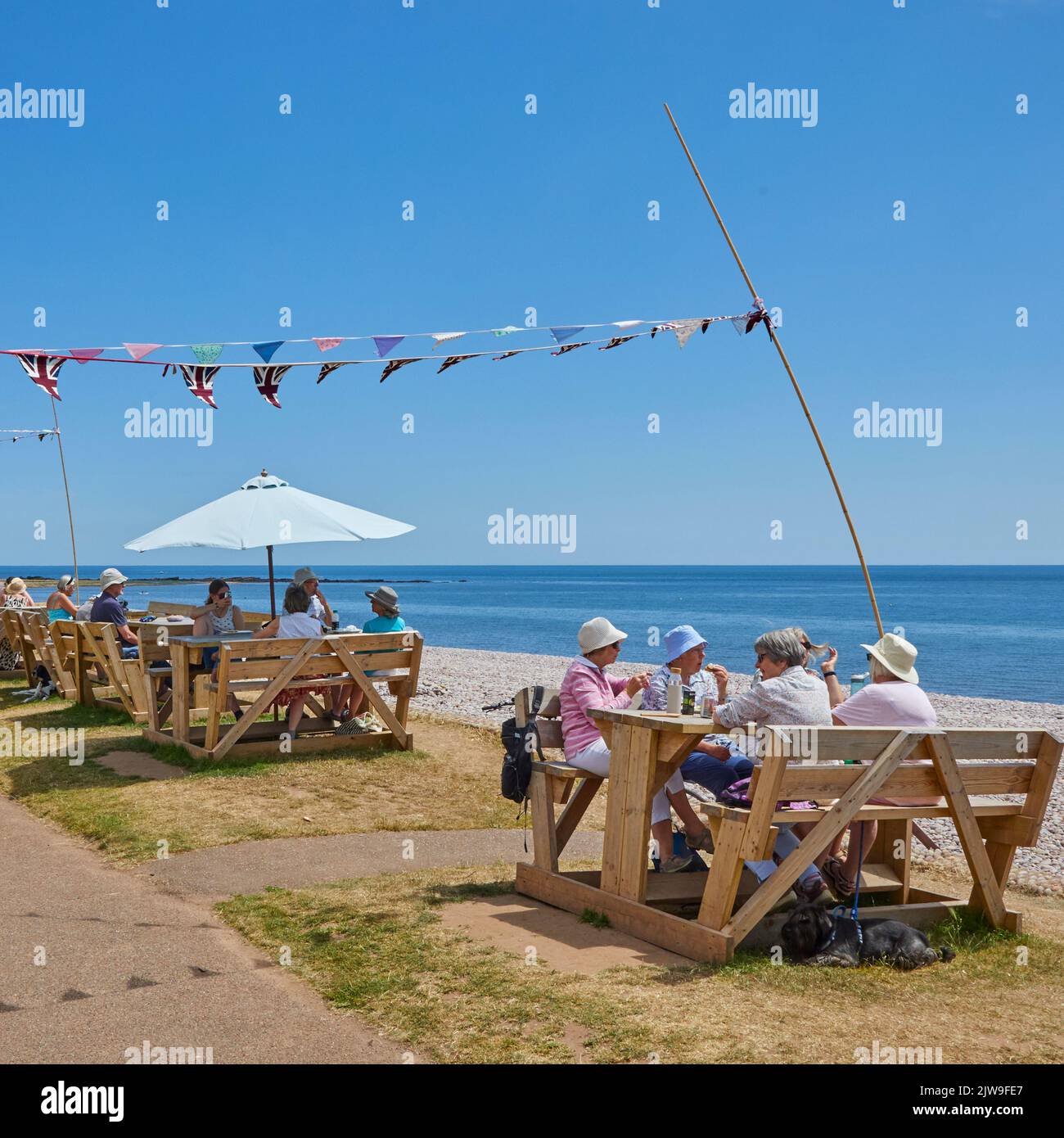 People enjoying the sunshine on the coast at Budleigh Salterton, South ...