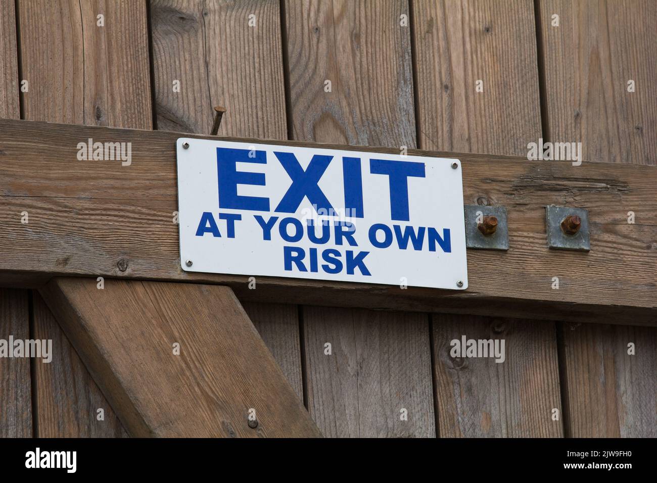 Exit sign warning of risk Stock Photo - Alamy