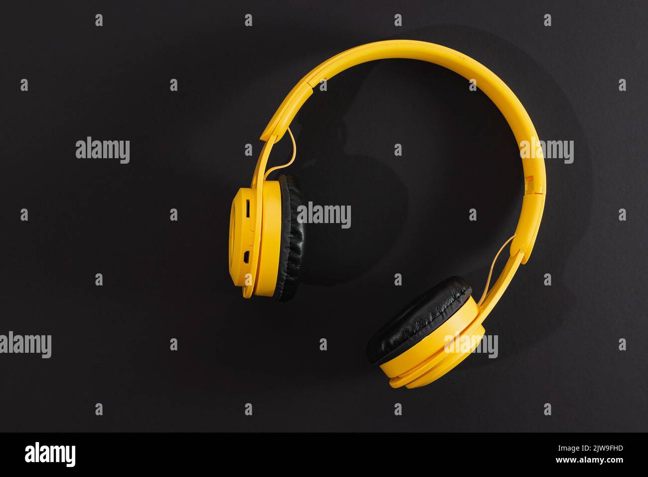 Yellow wireless headphones isolated on a dark background Stock Photo ...