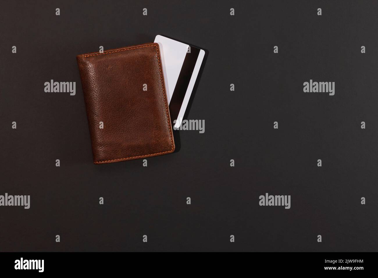 A brown leather wallet and a white credit card seen from the magnetic ...