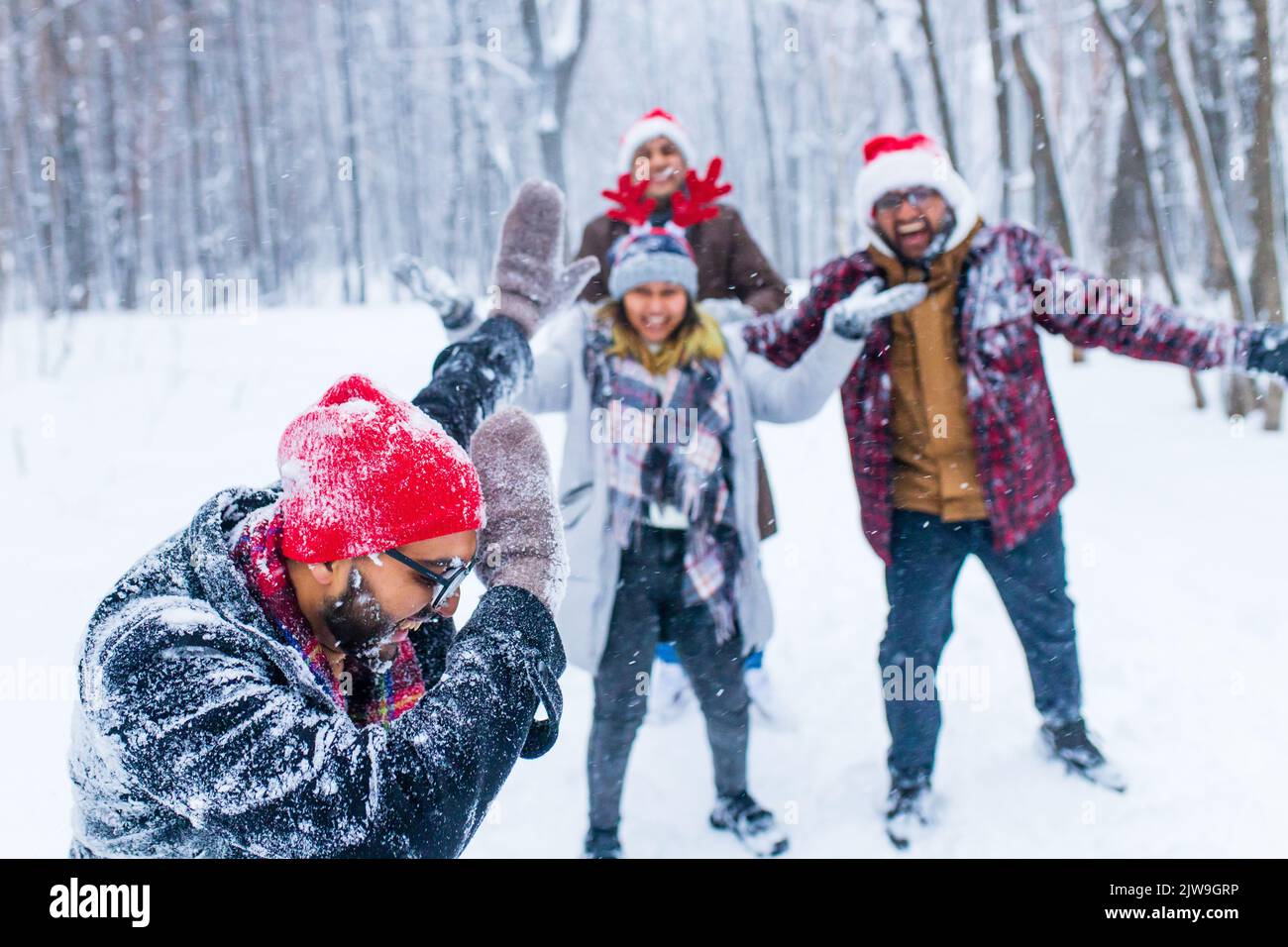 four happy friends are having fun and throwing snow Stock Photo - Alamy