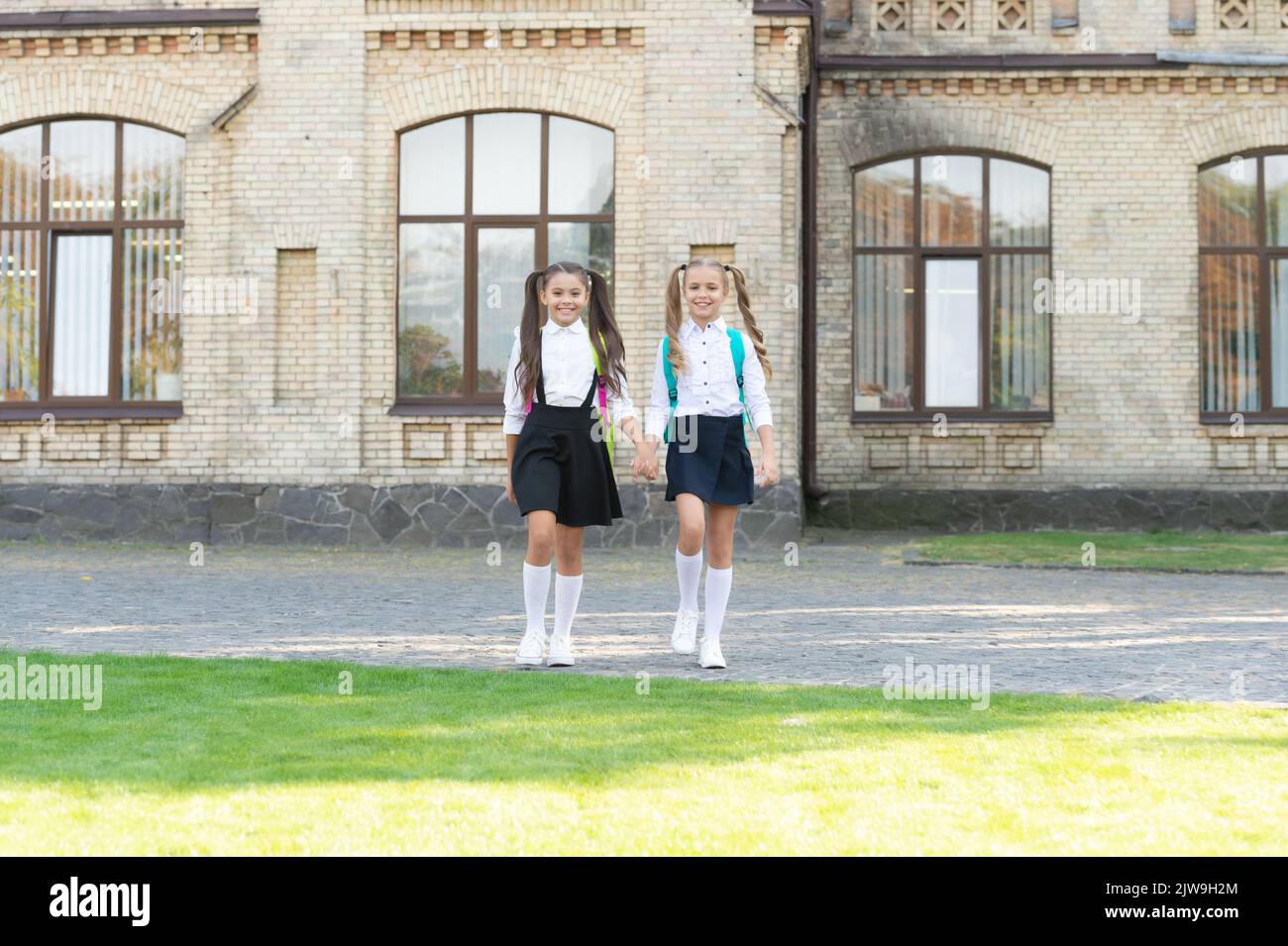 two schoolkids in uniform walking together outdoor Stock Photo - Alamy