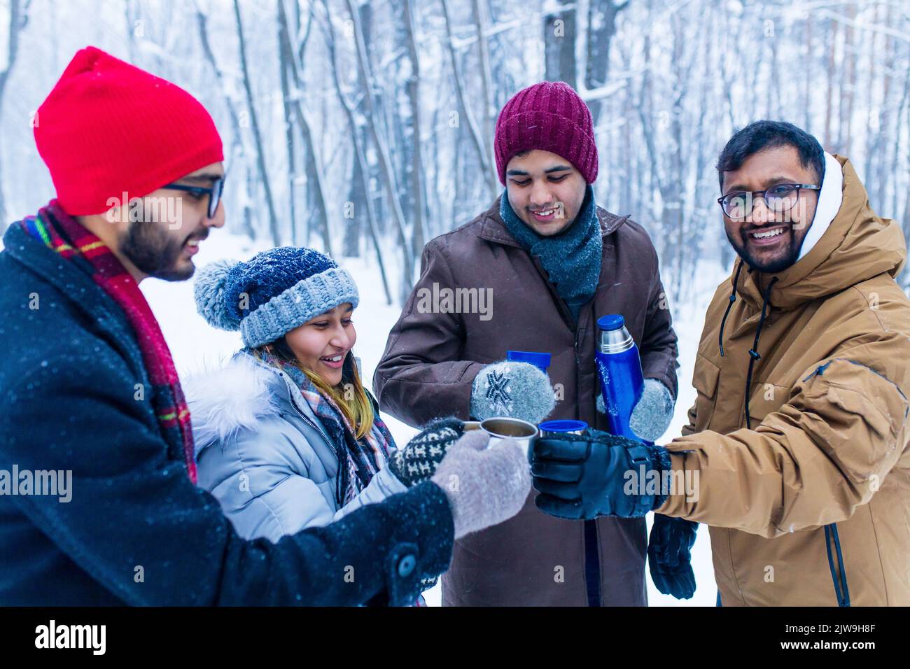 Happy young indian friends get warming with hot tea Stock Photo - Alamy