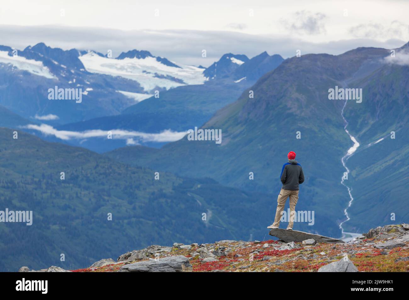 Hiker overview Mountains of Alaska in summer. Snow covered massifs ...