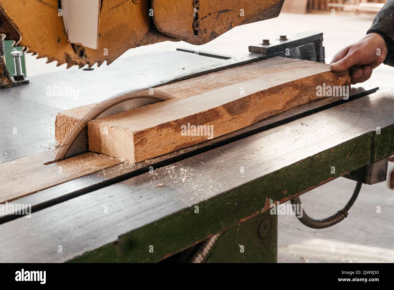 The blade of a circular saw on the desktop cuts a pine board Stock ...