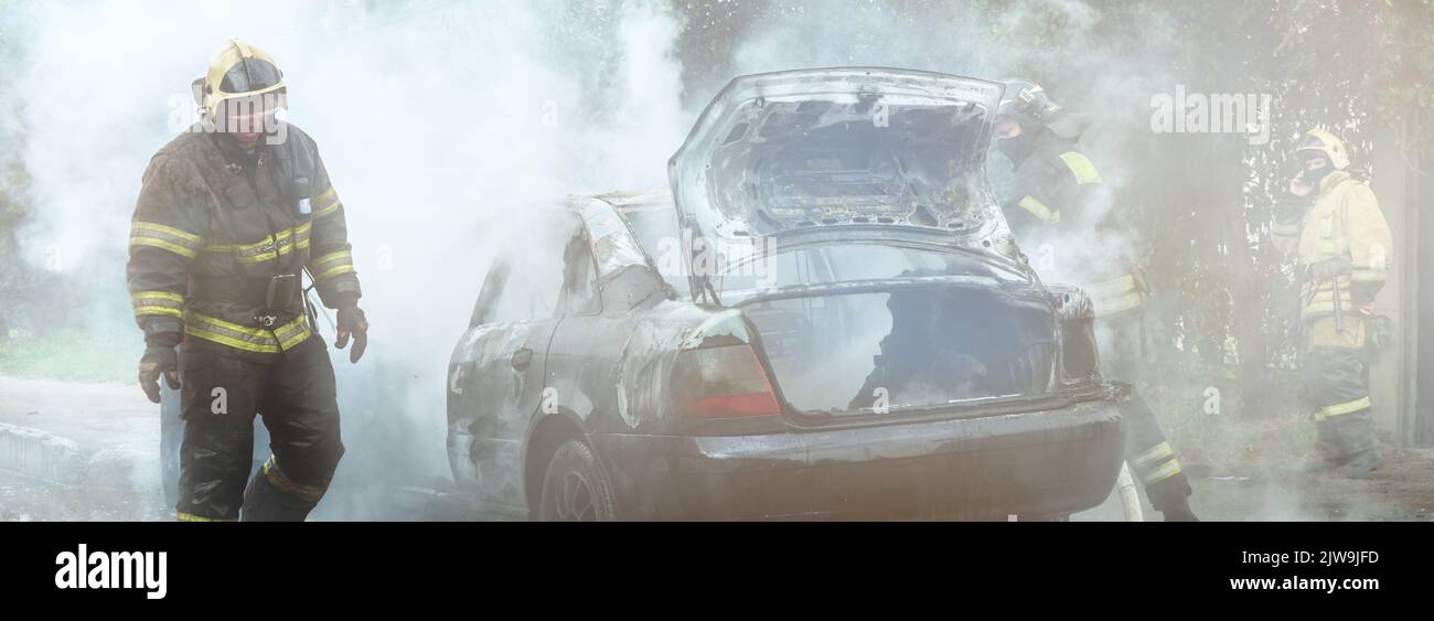 The fire brigade extinguishes a burning car. Arson of a car in the city ...