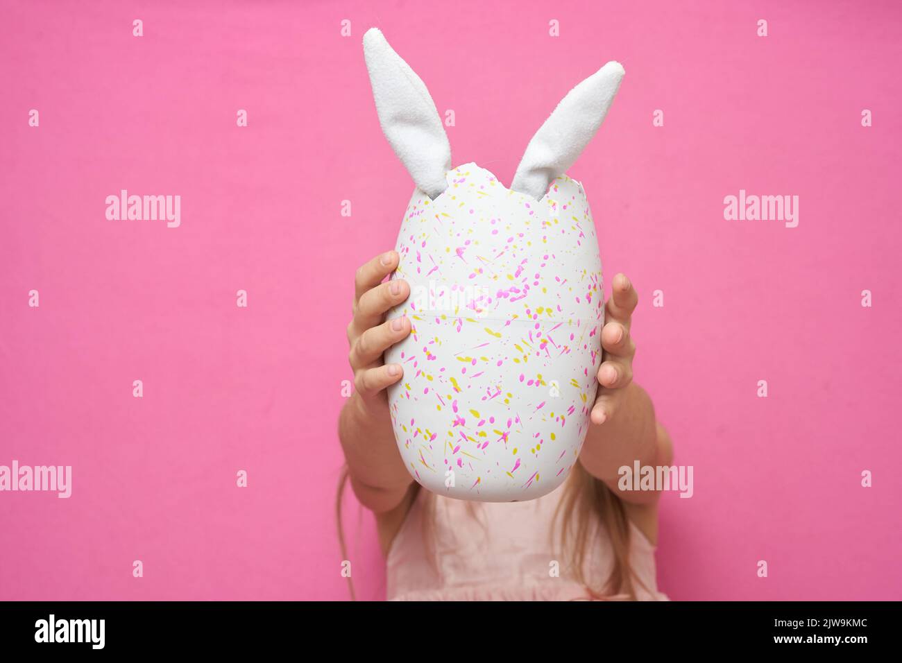 A little girl, unrecognizable, holds out a large souvenir in the form ...