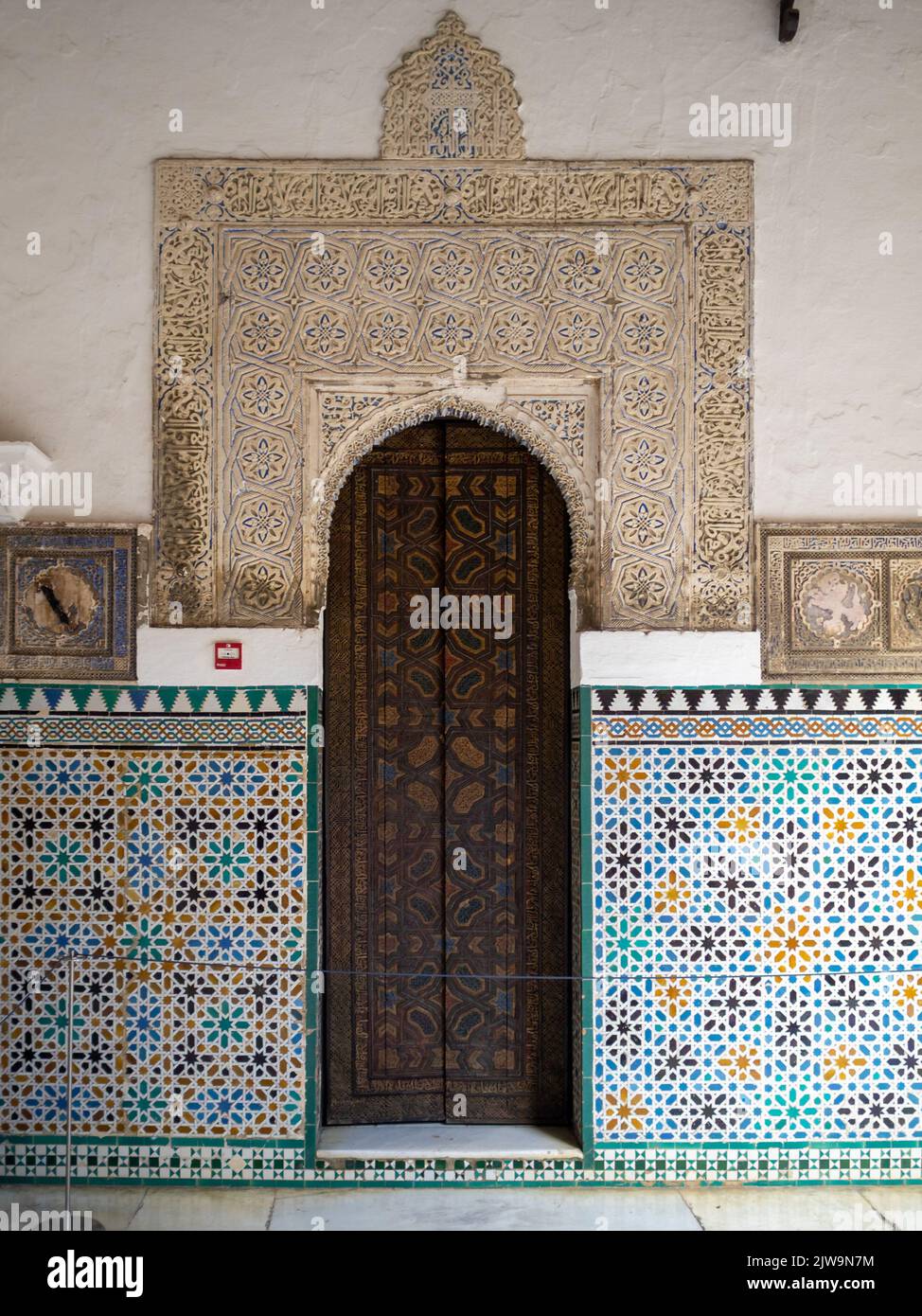 Islamic stucco, geometric patterned tiles and inlaid wooden door ...